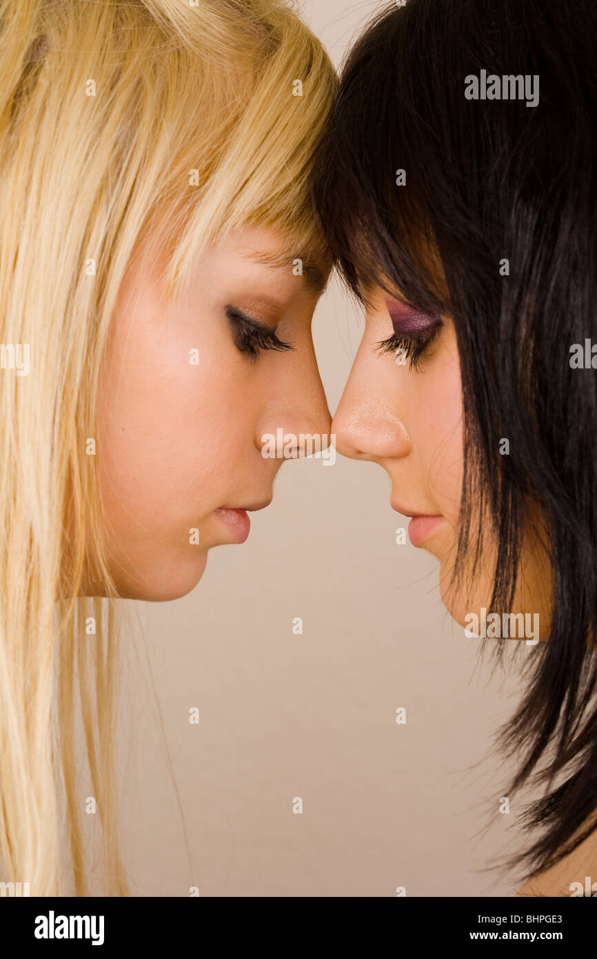 Close up portrait of two beautiful girls with opposite hair color ...