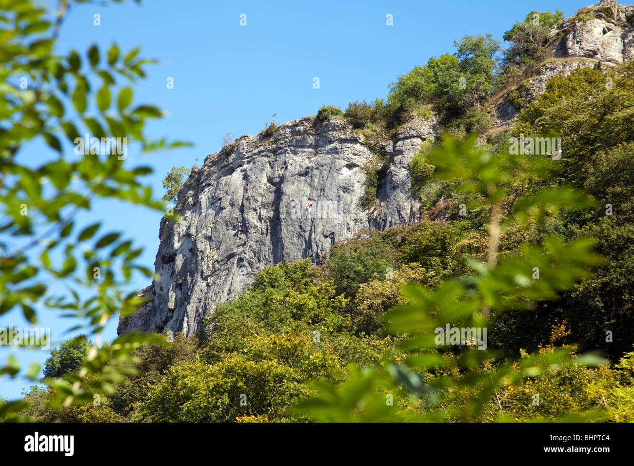 Rock climbers can barely be seen climbing the sheer rock face in the ...