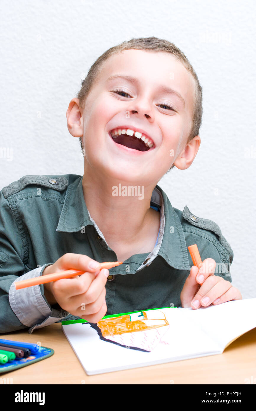 Portrait of a cute schoolboy drawing Stock Photo - Alamy