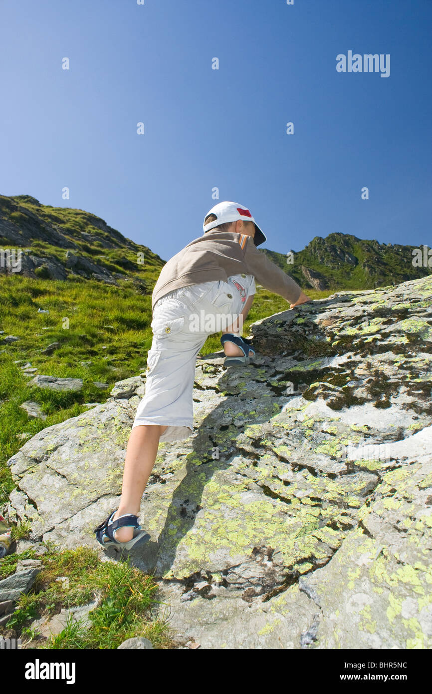 Young boy climbing up on a mountain Stock Photo - Alamy