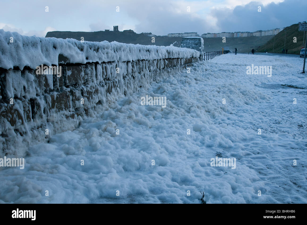 Strong winds blow foam across seafront wall in winter, Scarborough ...