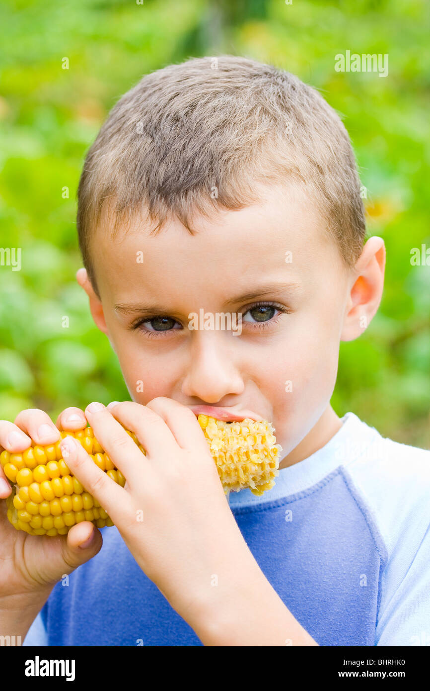 Boy eating fresh boiled corn Stock Photo - Alamy