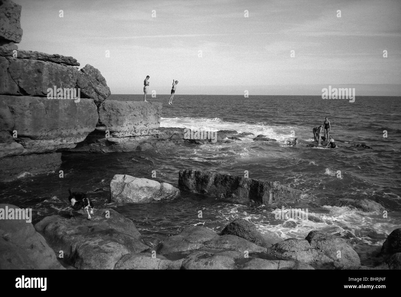 People jumping off rocks into the sea Stock Photo - Alamy