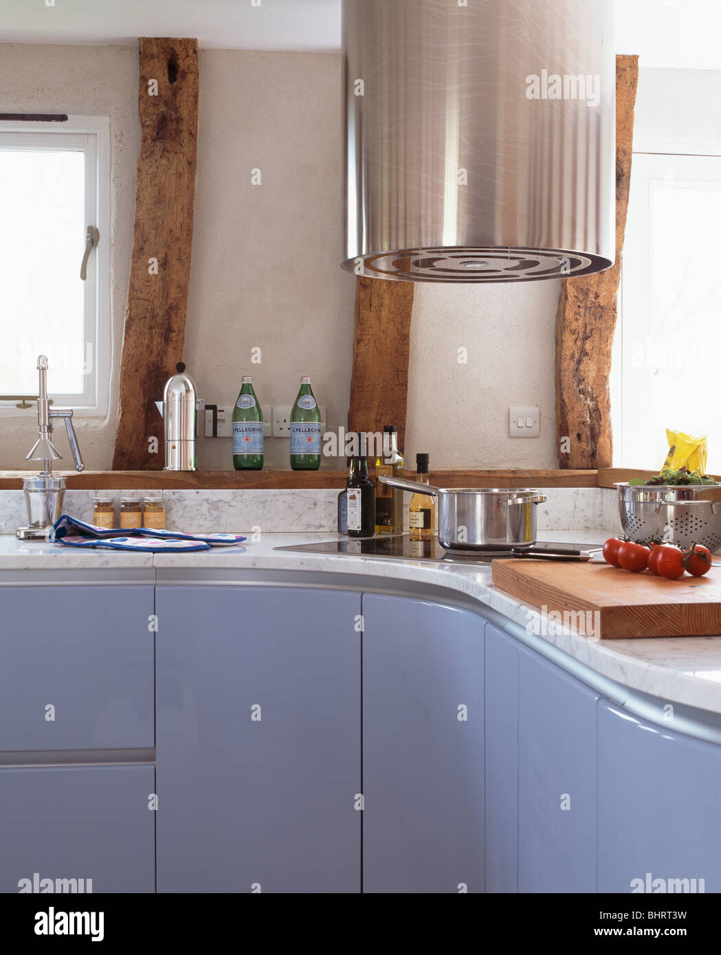 Stainless steel cylindrical extractor above corner hob in modern ...