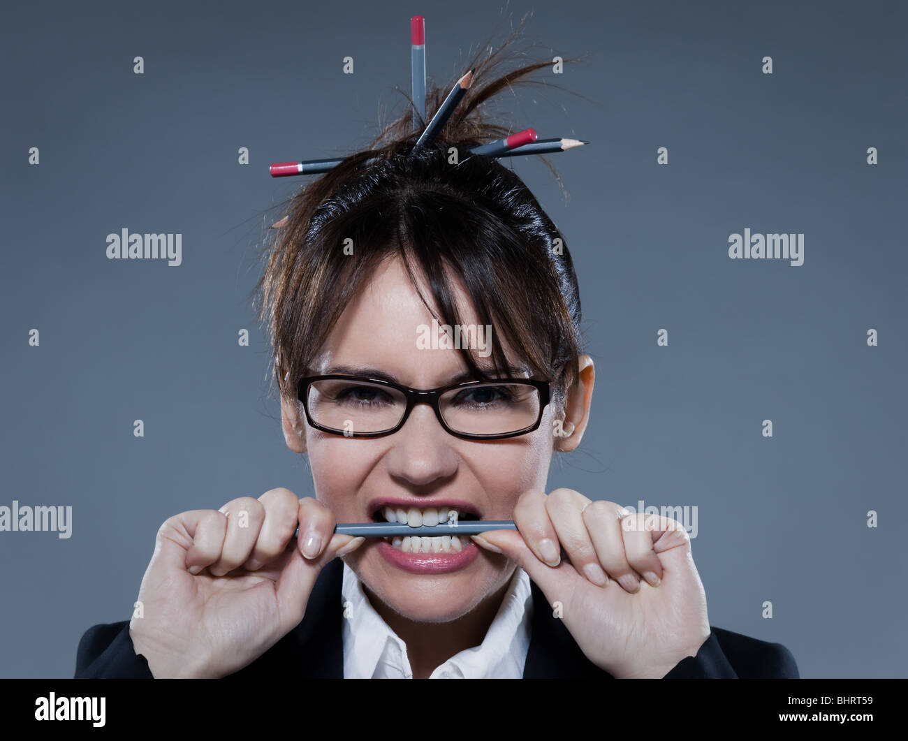 Angry woman biting pencil hi-res stock photography and images - Alamy