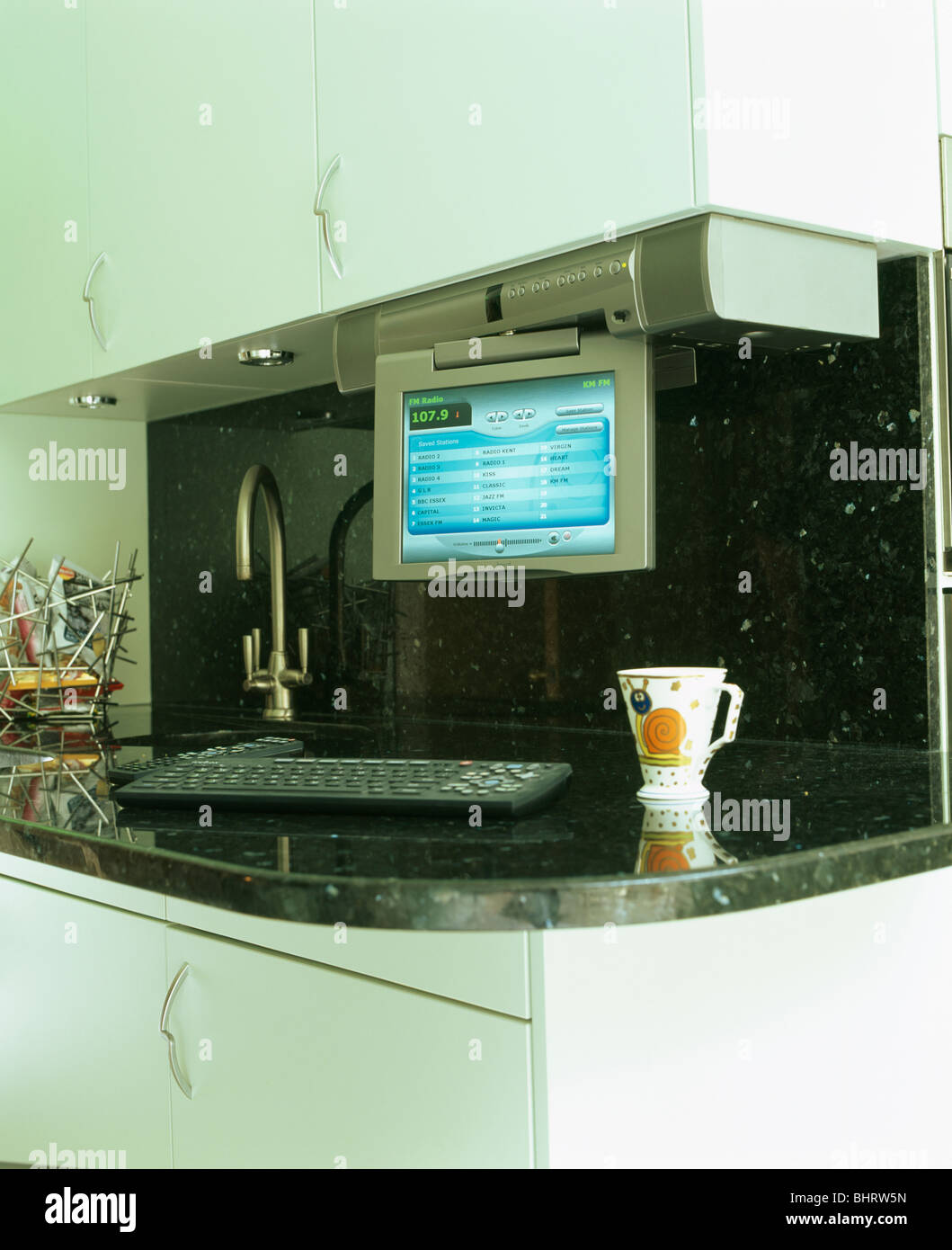 Close-up of computer keyboard and monitor on worktop in modern kitchen ...
