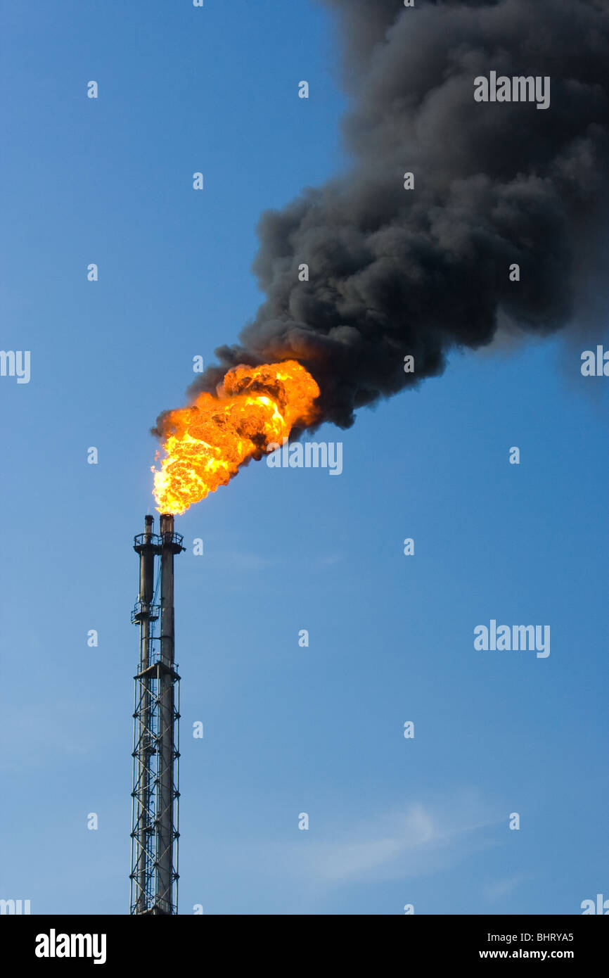 Factory funnel burning with large flame and throwing thick cloud of ...