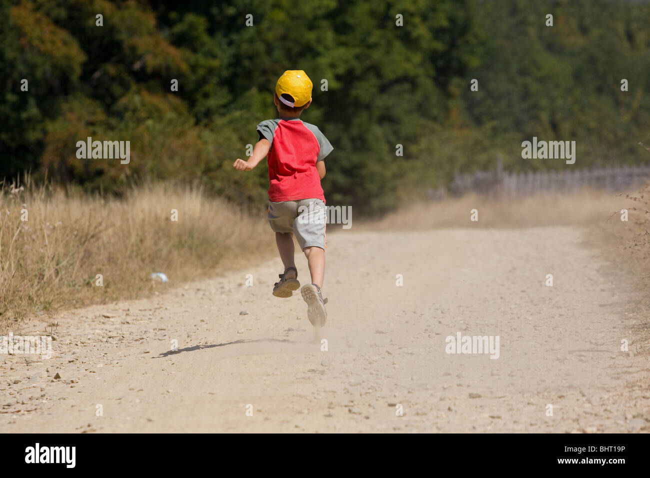 Seven year old kid running on a dusty road in the countryside Stock ...