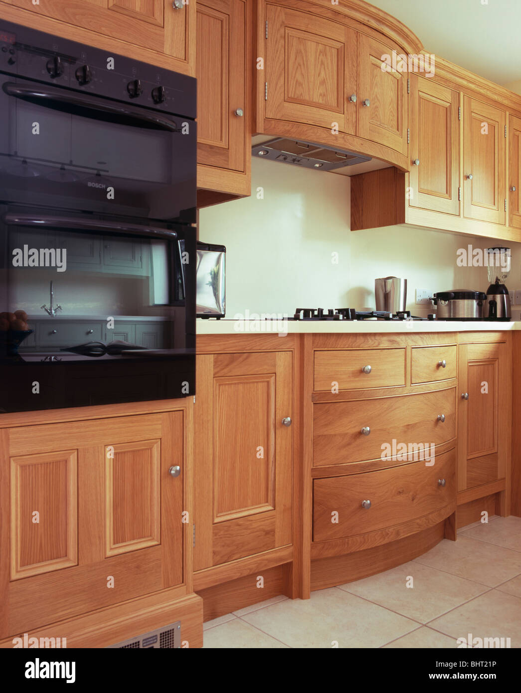 Eye-level black oven in fitted cherry-wood unit in town-house kitchen ...