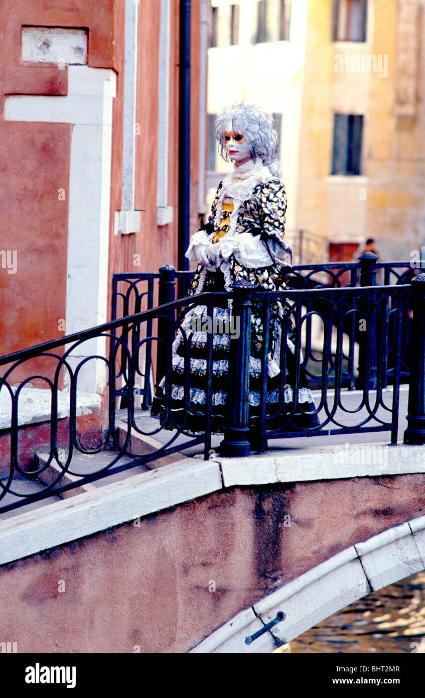 Lady in costume crossing over a small bridge in Venice during the ...