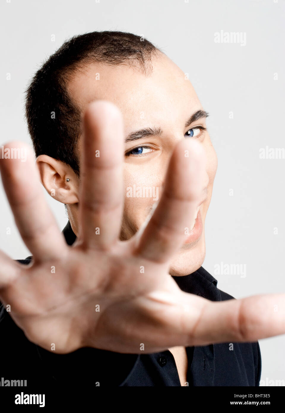 Fashion portrait of a young man with the hand in front of the face ...