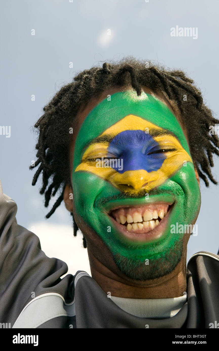 a happy and cheering Brazil football supporter with the Brazil flag ...