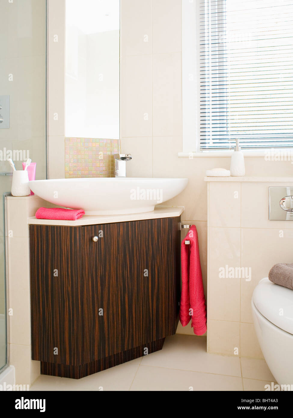 White oval bowl-basin on dark wood vanity unit in modern cream bathroom ...