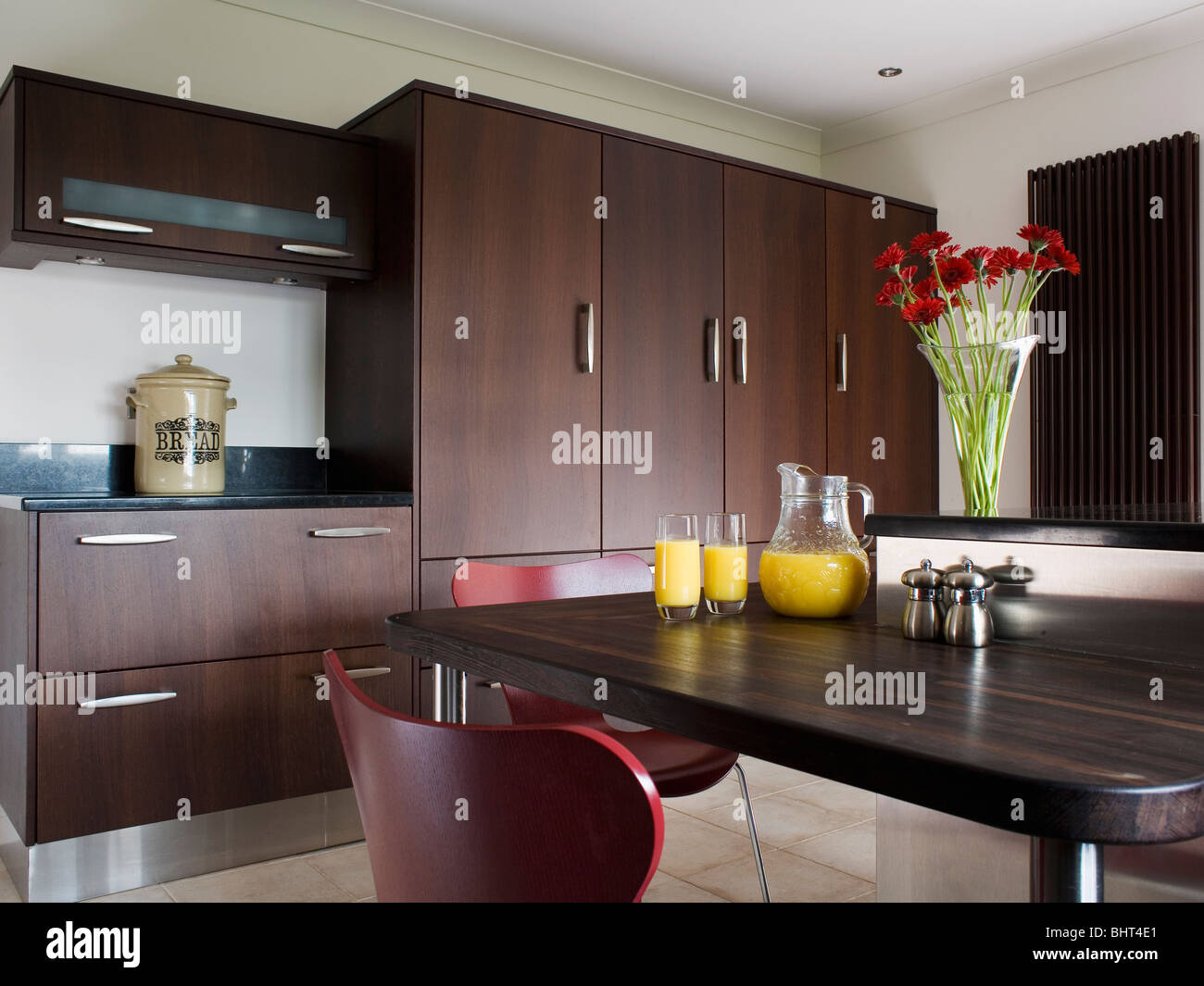 Dark brown fitted units and cupboards in modern townhouse kitchen with ...