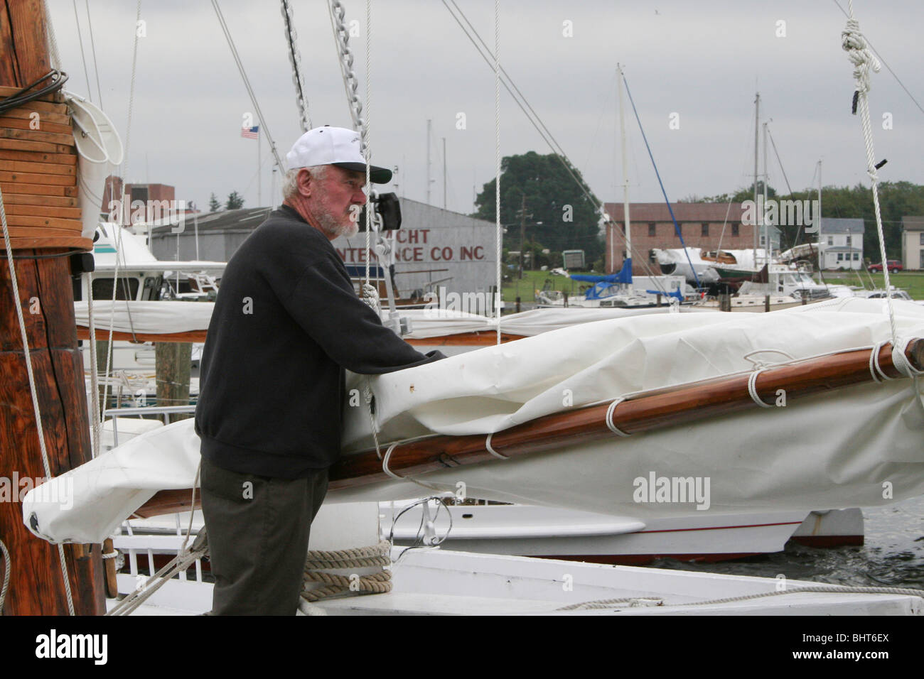 Skipjack sailor adjusting the furl Stock Photo - Alamy