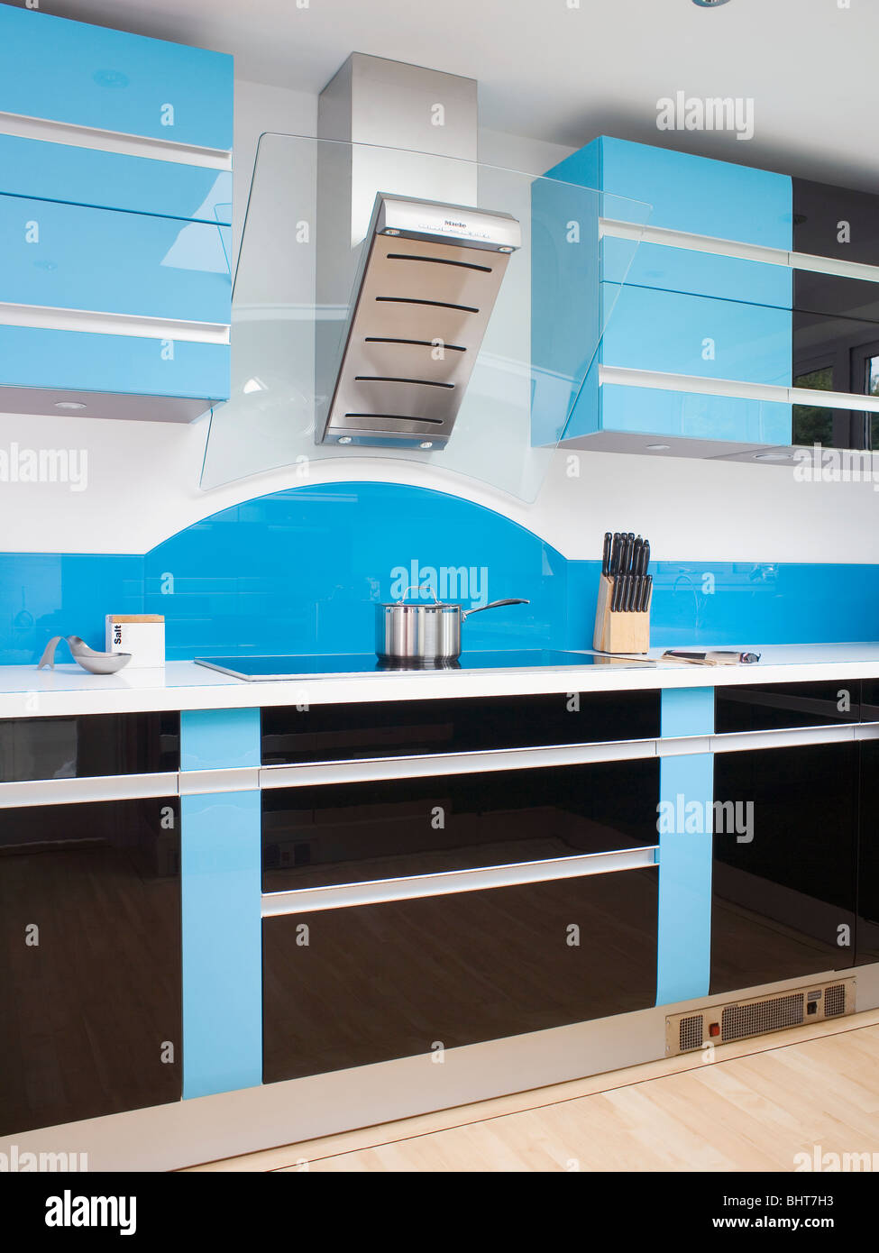 Stainless-steel and glass extractor above hob in modern kitchen with ...