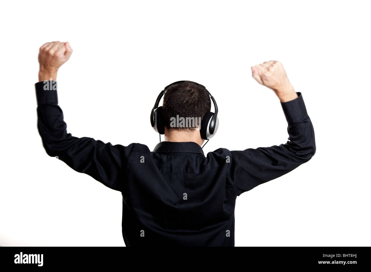 Back view of a young man listening music with headphones, isolated on ...
