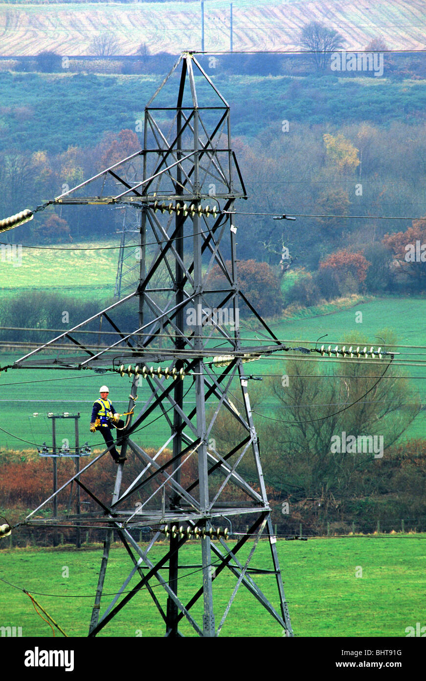 utility linemen working atop a high tension power line pylon Stock ...