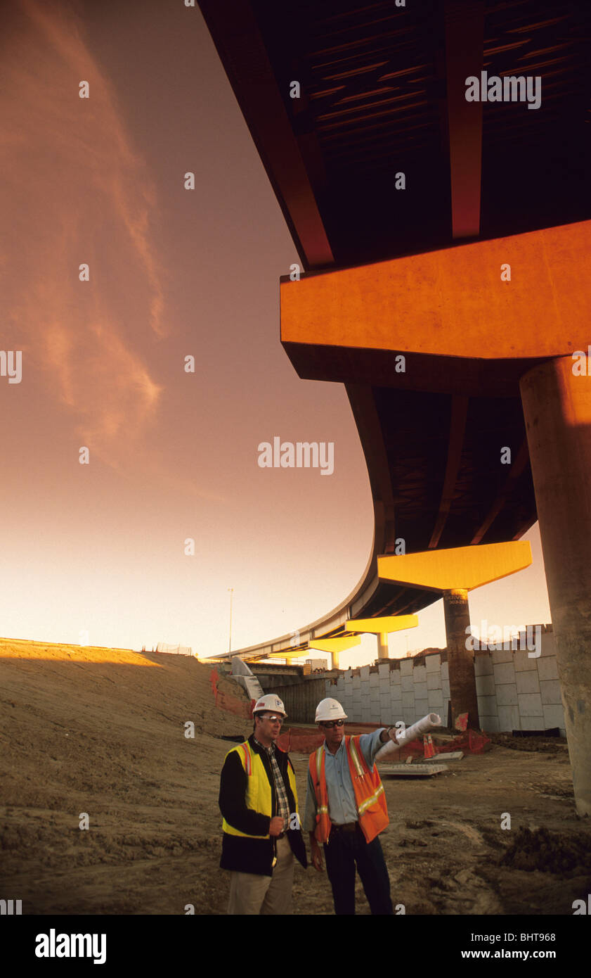 two construction workers under freeway overpass under costruction Stock ...
