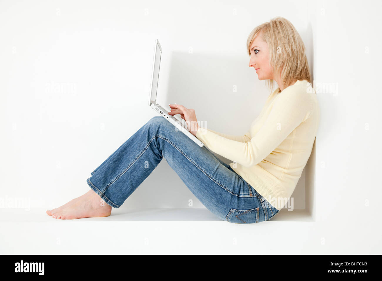 young woman with bare feet using laptop Stock Photo - Alamy