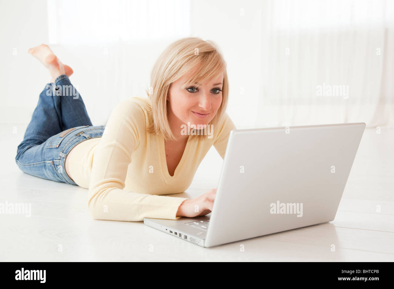 young woman lying on the floor using a laptop Stock Photo - Alamy