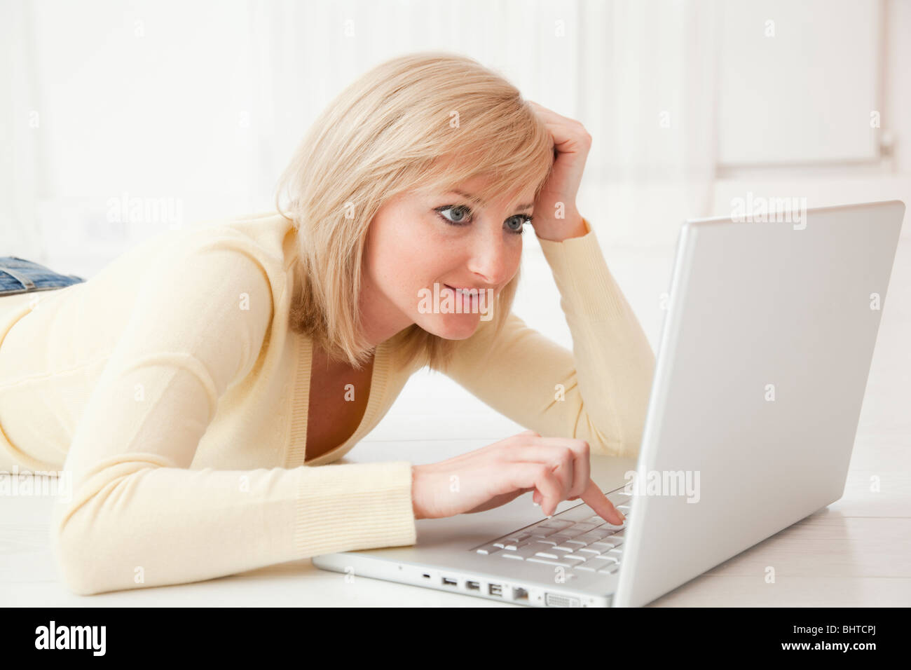 young woman lying on the floor using a laptop Stock Photo - Alamy