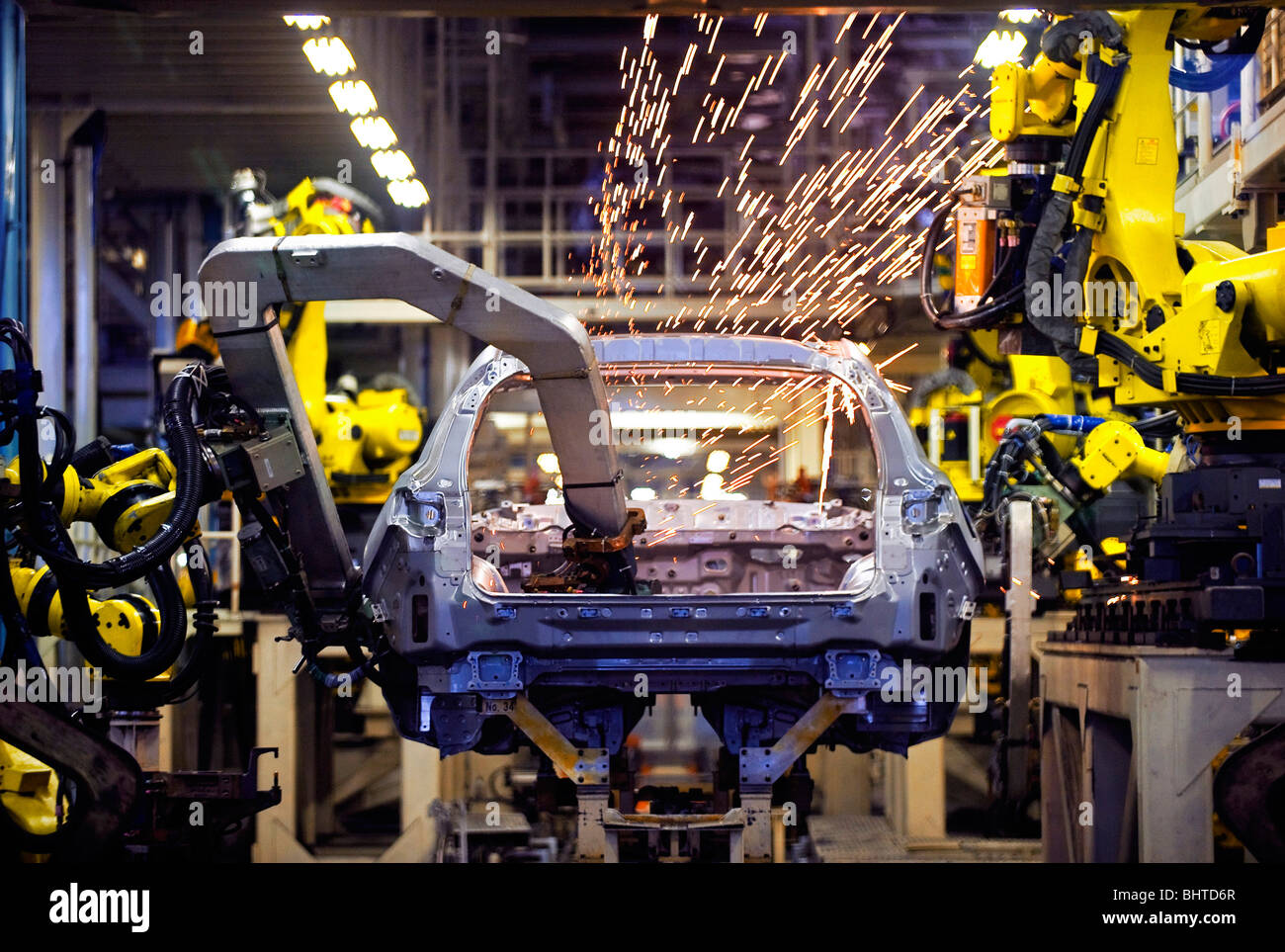 Robots get to work on the body of a new Nissan Motor Co. vehicle at the ...