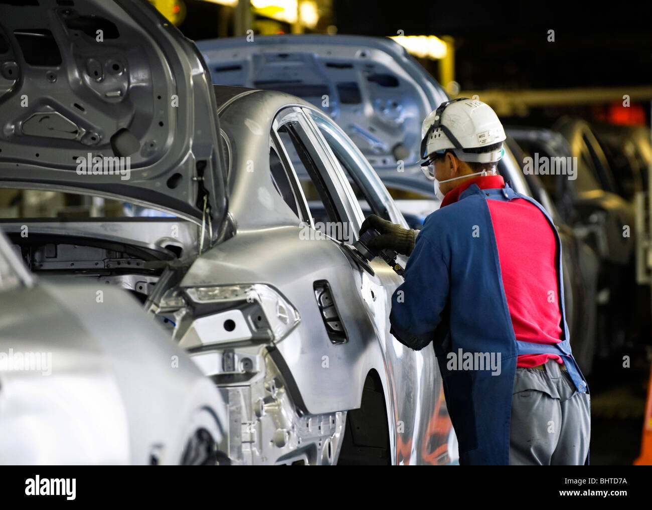 A worker works on a vehicle at Nissan Motor Co.s assembly plant in ...
