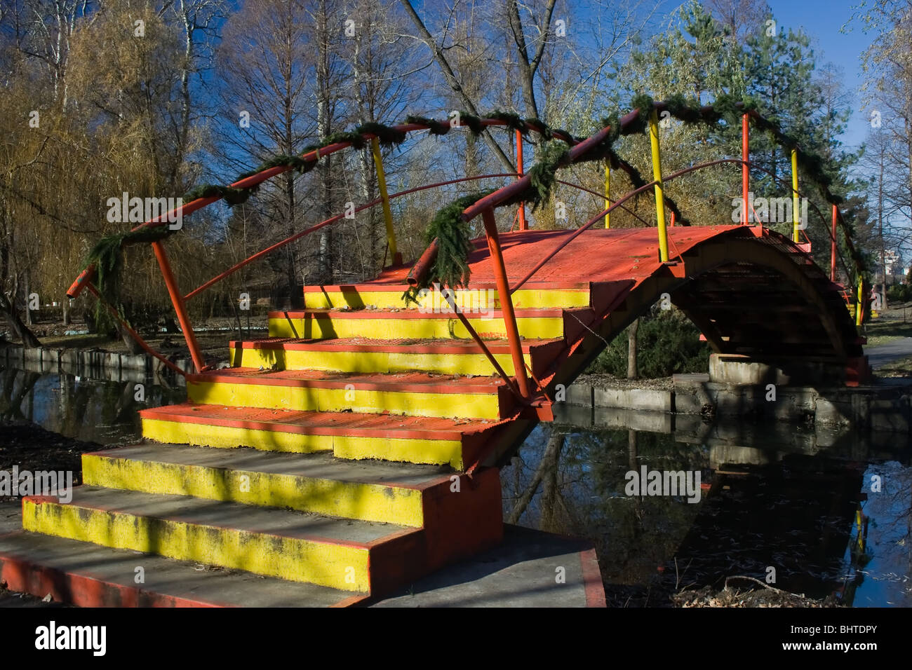 Colored bridge over a small lake in a park Stock Photo - Alamy