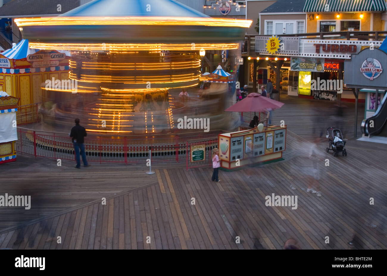 Main watching his child on merry-go-round, Pier 39, San Francisco ...