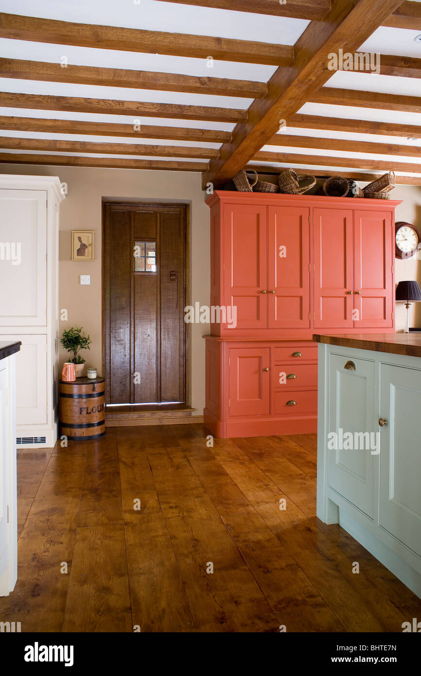 Large red cupboard in country kitchen with wooden floor-boards and ...