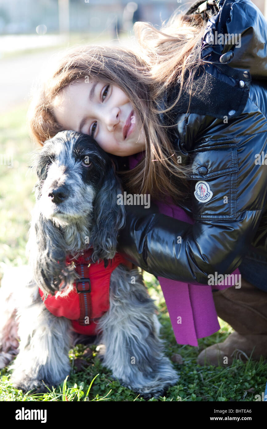 Young 9 year Caucasian girl hugging her cocker spaniel blue roan ...
