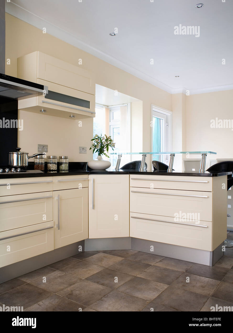 Cream fitted units in modern town-house kitchen Stock Photo - Alamy