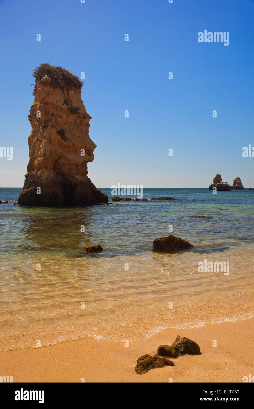 Rocks in the sea and the beach under a blue sky in Algarve Stock Photo ...