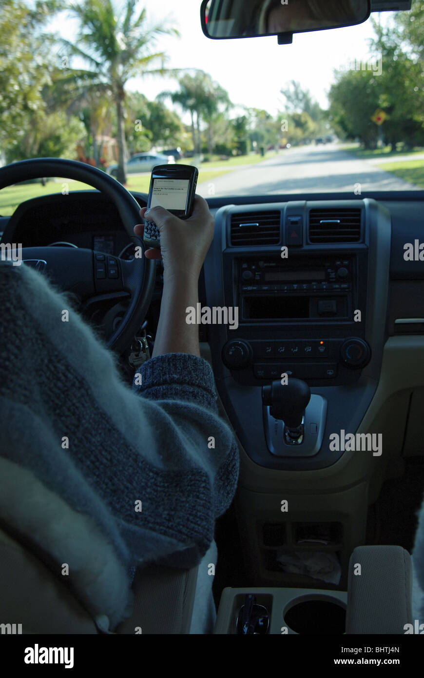 Woman is using PDA to check and type text messages while driving her ...