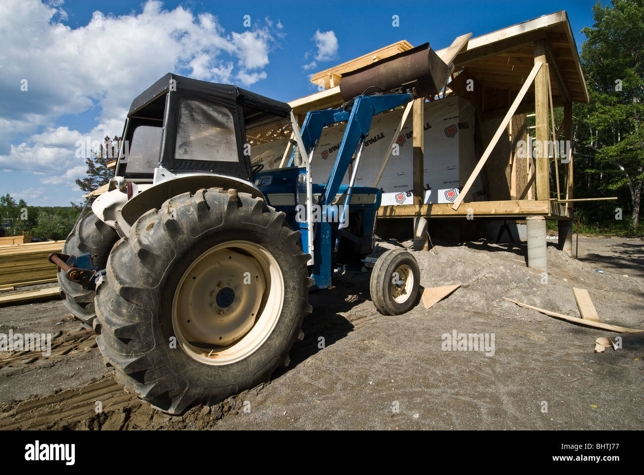 Farm tractor used to lift materials to the roof a new residential home ...