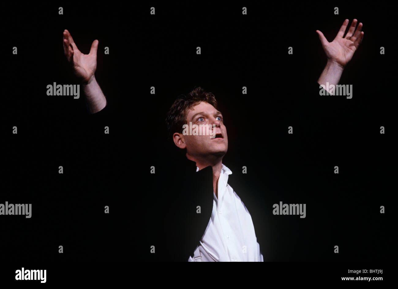 A young wide-eyed Shakespearean Kenneth Branagh reaches up theatrically ...