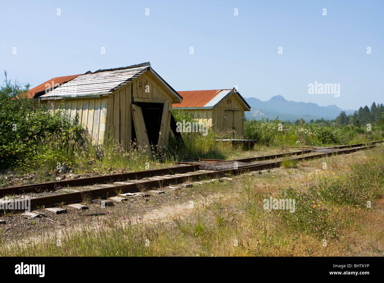 Two old buildings by railroad tracks Stock Photo - Alamy