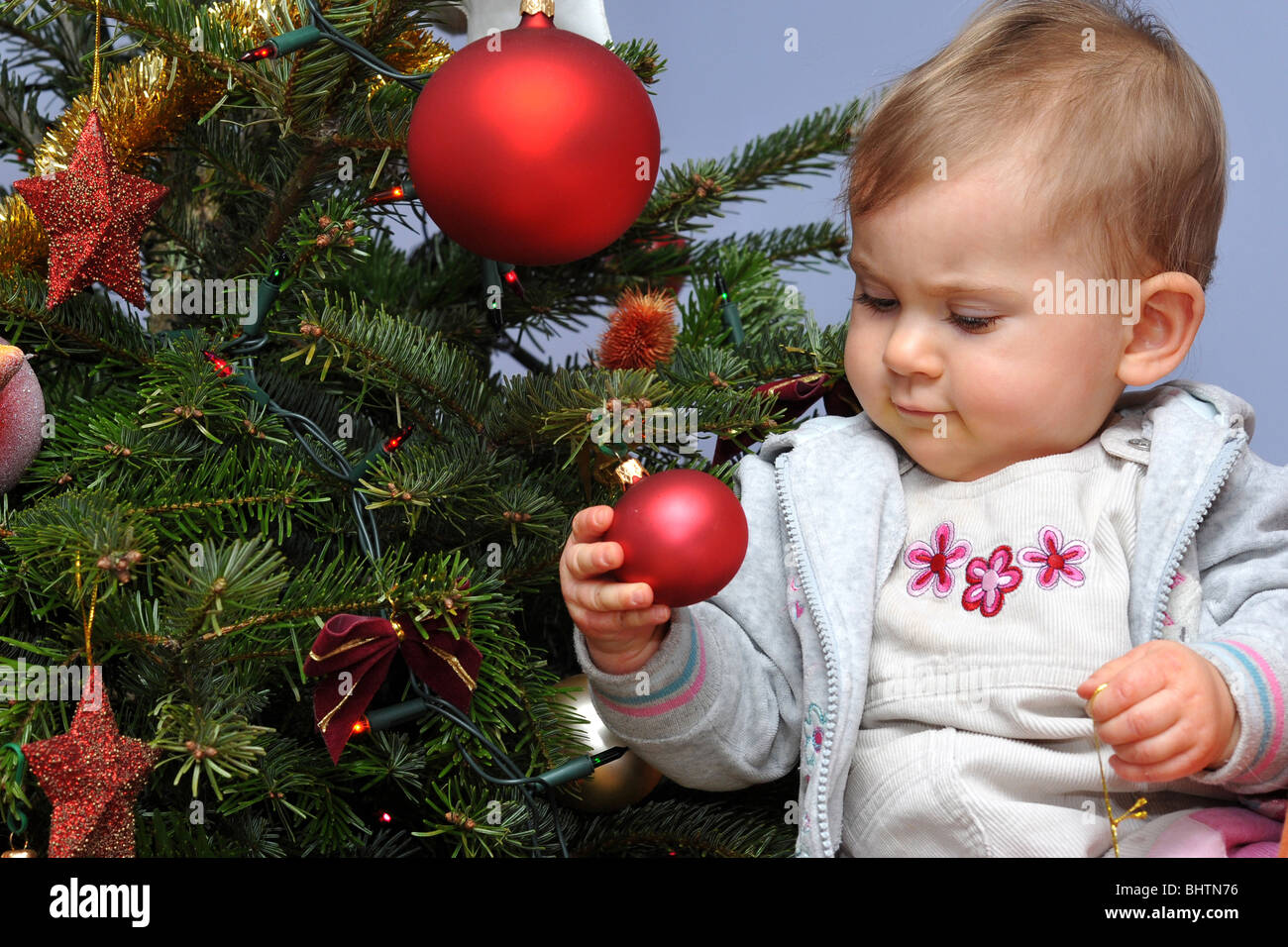 Baby and christmas tree Stock Photo - Alamy