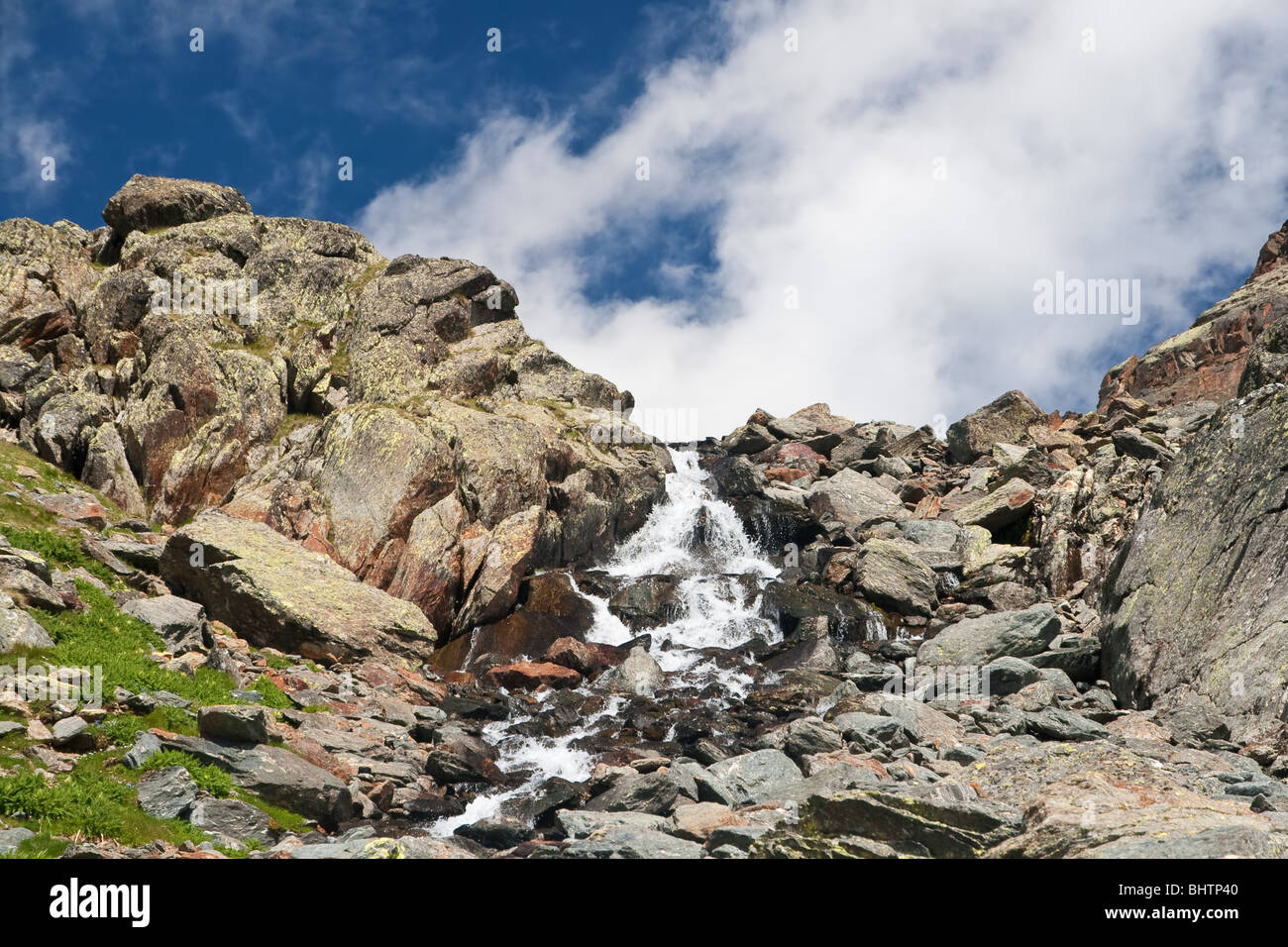 fresh waters are flowing with a small cascade under a blue sky. Photo ...