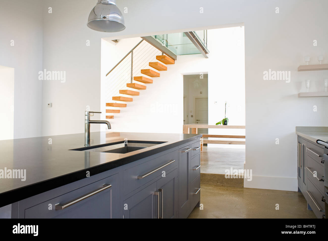 Island unit in modern open-plan kitchen with large doorway with view to ...