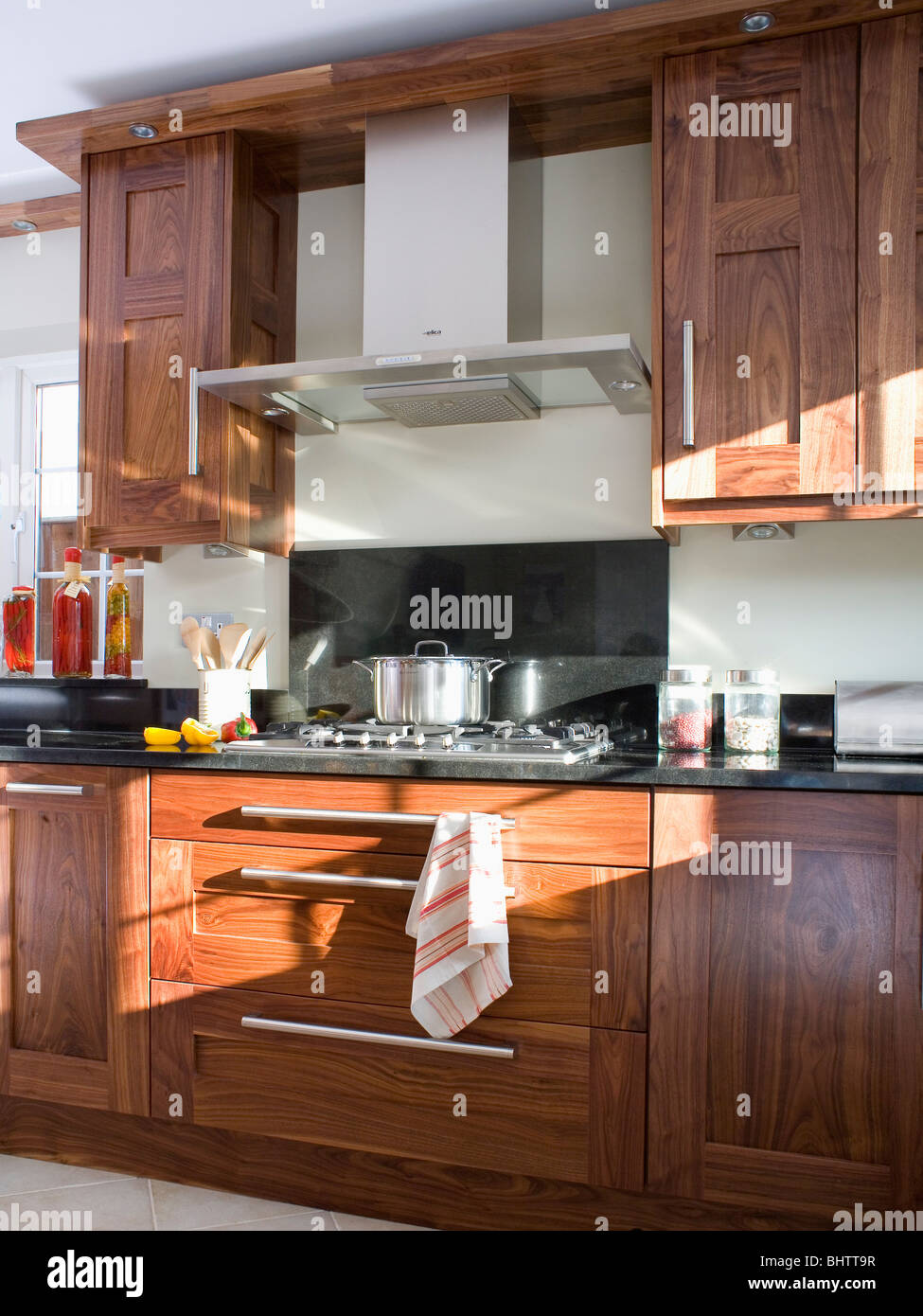 Extractor above hob in fitted cherry-wood unit in modern kitchen Stock ...