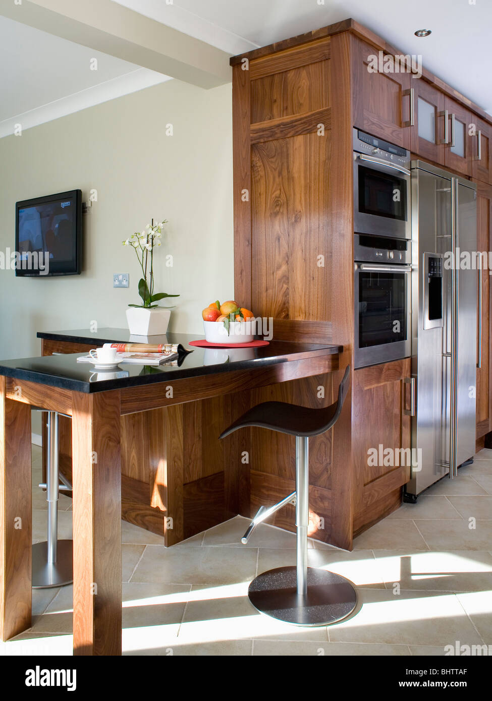 Fitted wood table in modern kitchen with dark walnut wood fitted units ...