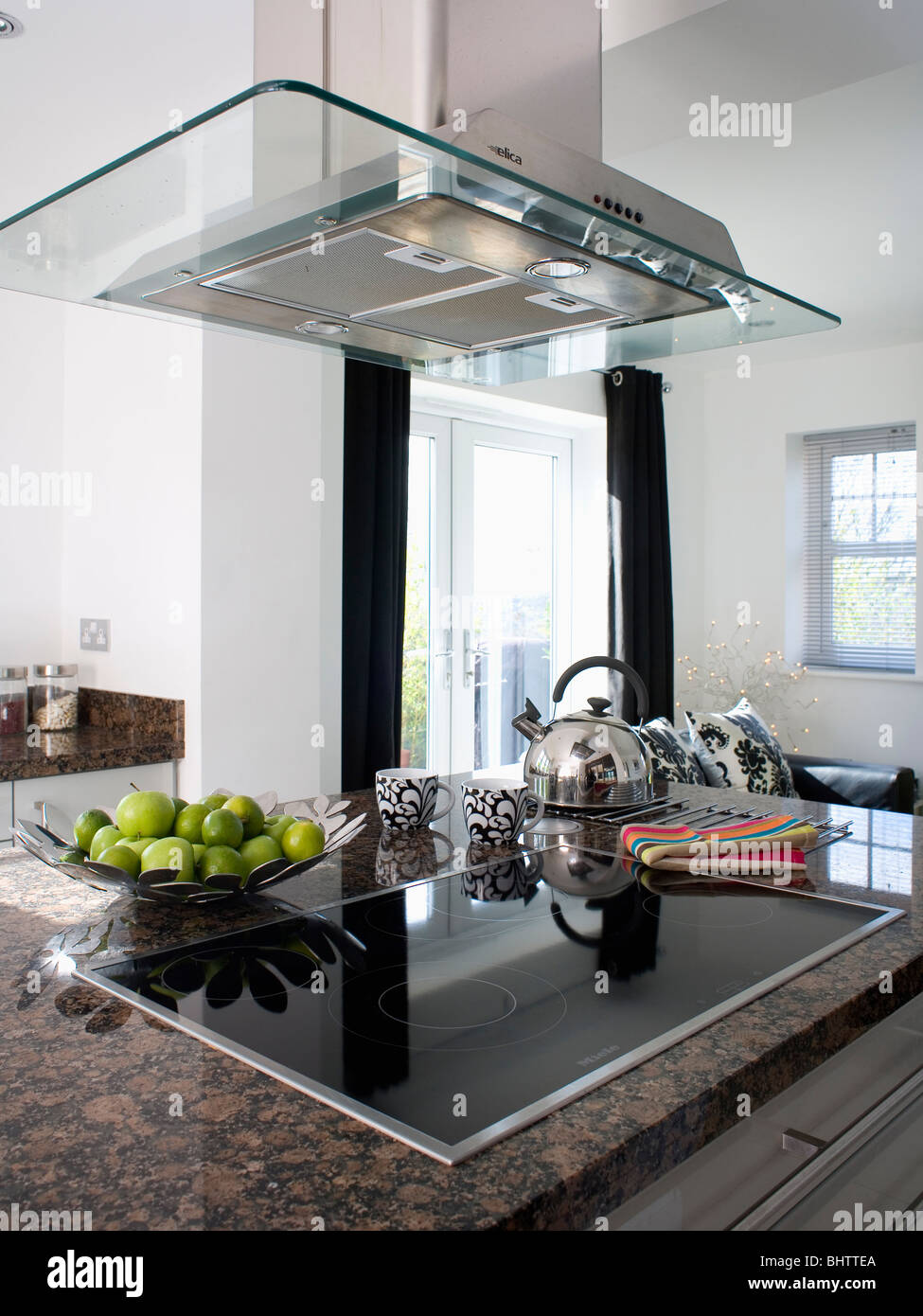 Large glass and steel extractor above halogen hob in modern kitchen ...