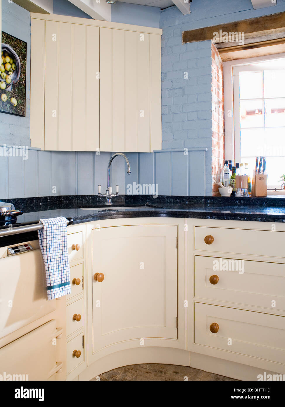Cream corner cupboard above sink in pale blue country kitchen with ...