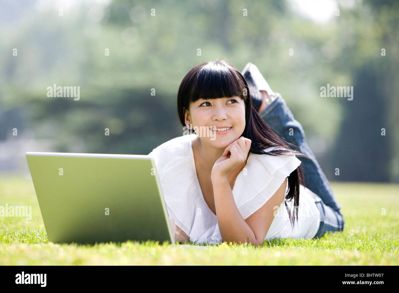 Young woman using laptop outdoors Stock Photo - Alamy