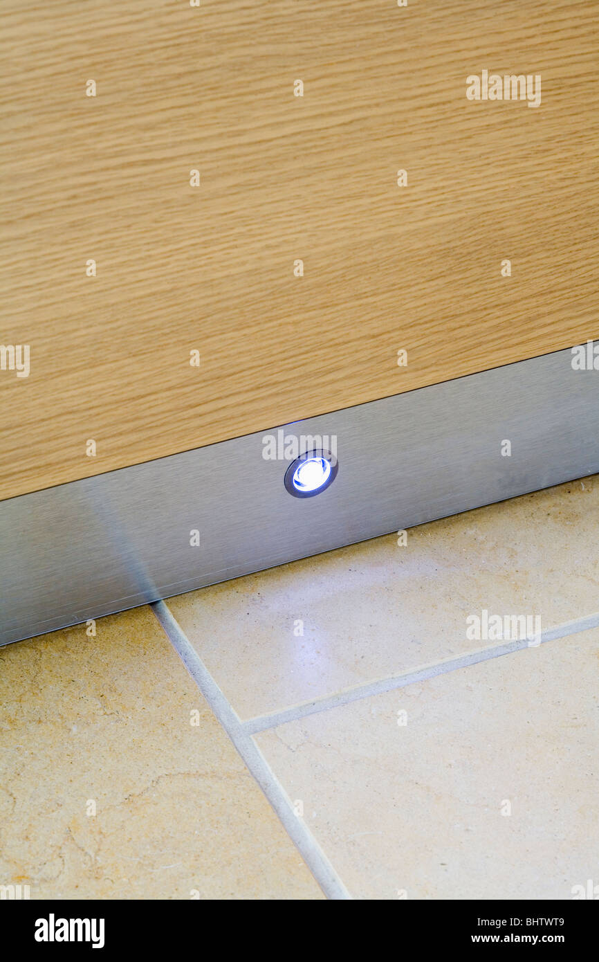 Close-up of halogen lighting on kick-board below kitchen cupboard Stock ...