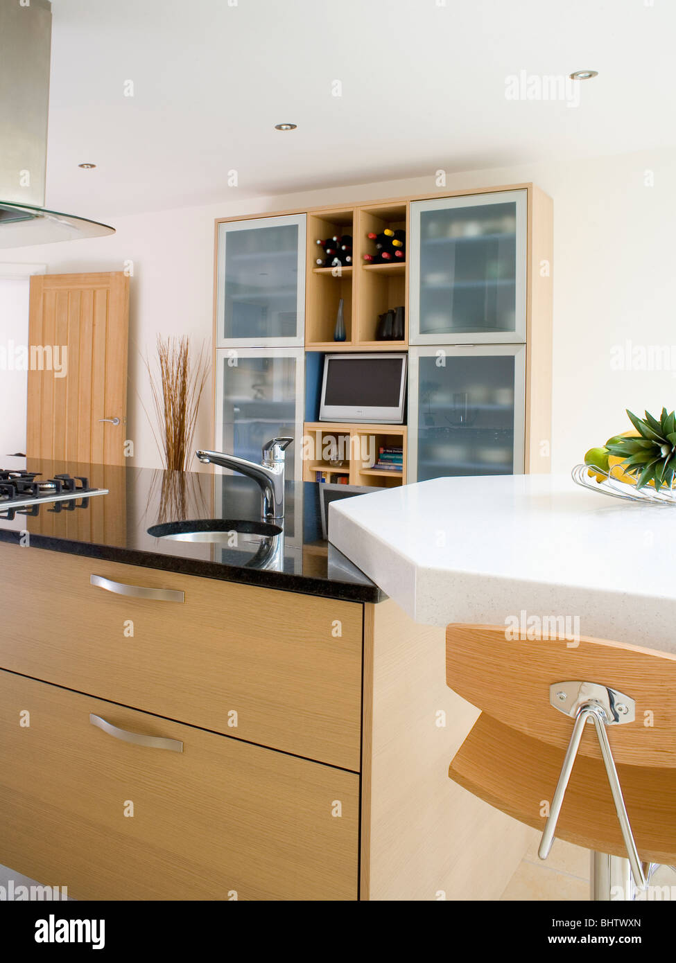 Small circular under-set sink in black granite worktop on island unit ...