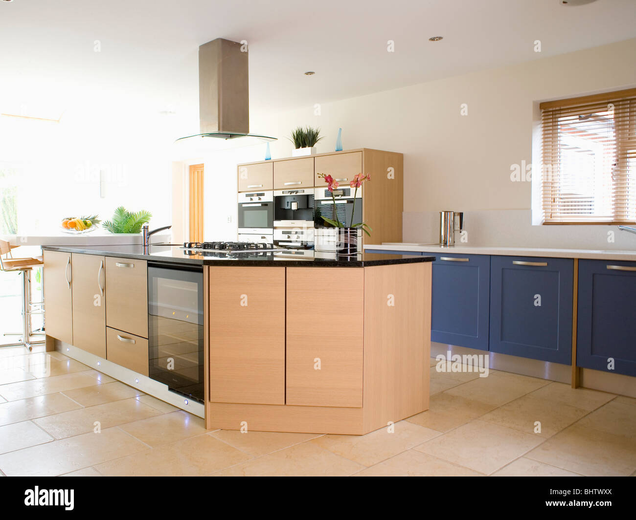 Island unit in large modern kitchen with limestone flooring Stock Photo ...