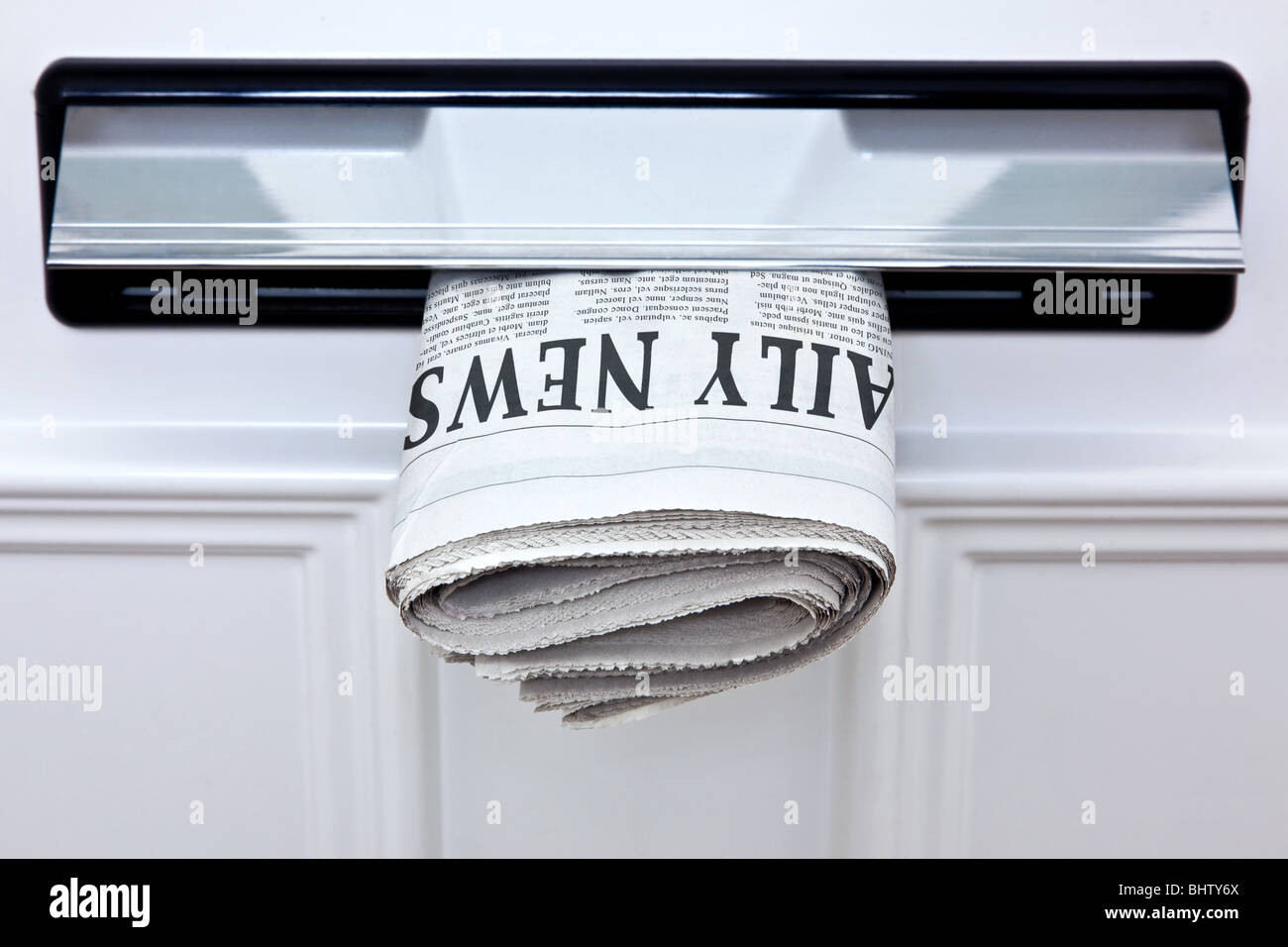 Newspaper sticking through a letterbox, the random text and title were ...